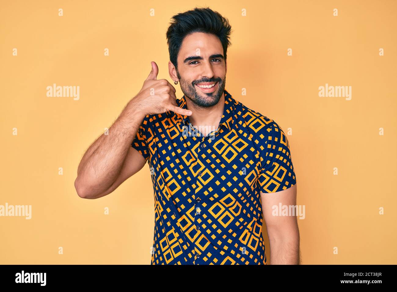 Handsome hispanic man with beard wearing 80s disco style shirt smiling ...