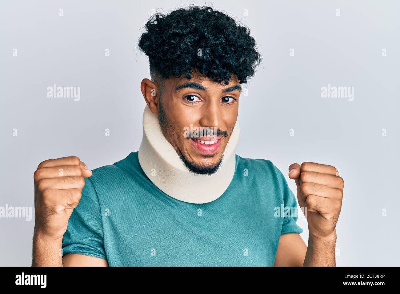 Young arab handsome man wearing cervical neck collar screaming proud ...