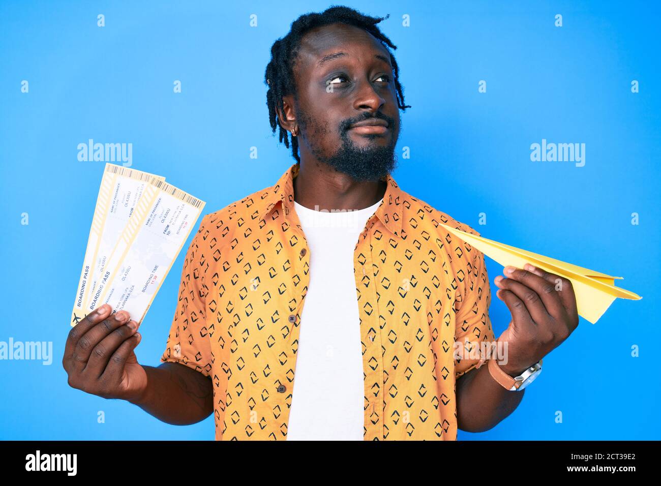 Young african american man with braids holding paper airplane and ...