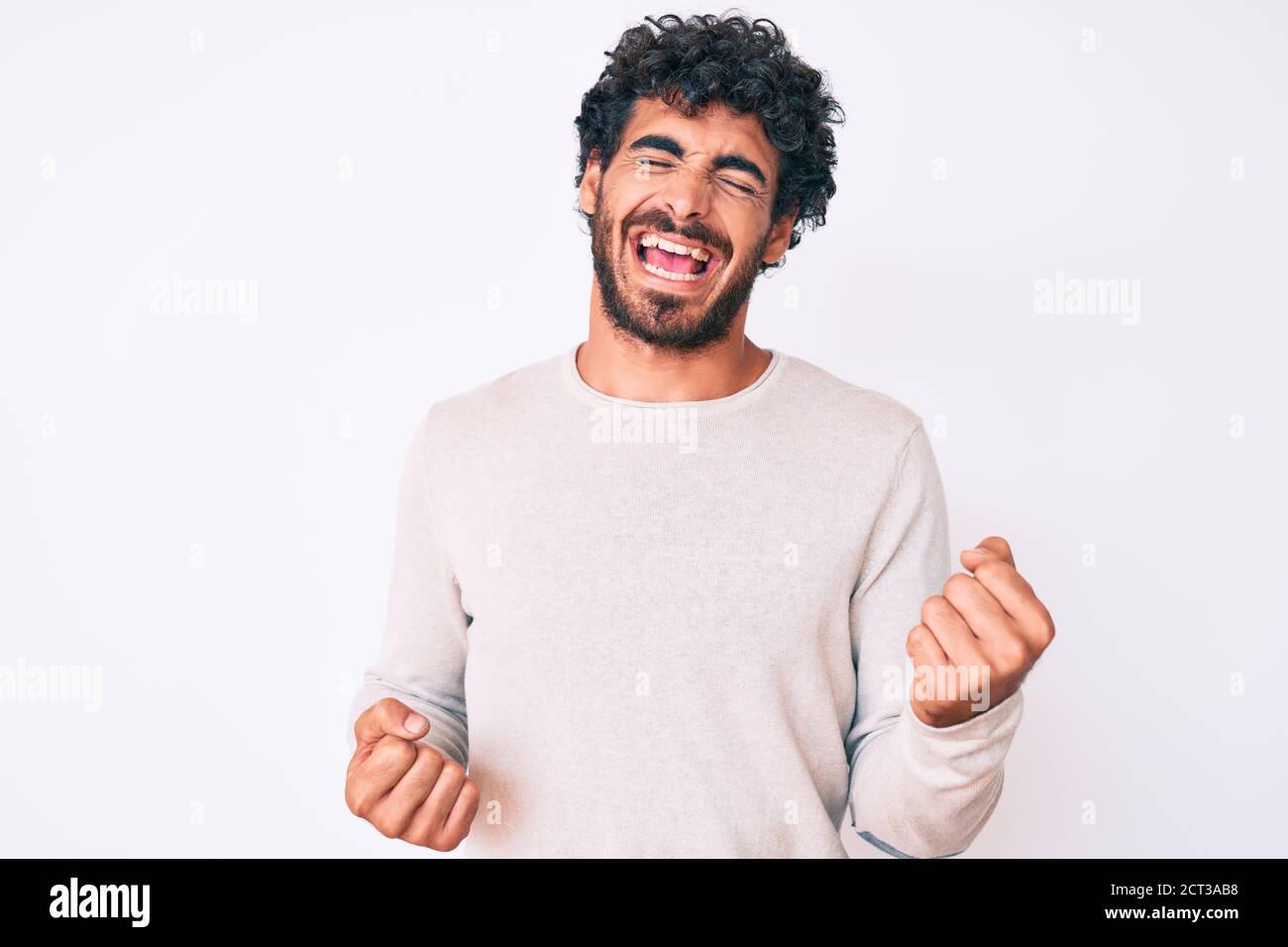 Handsome young man with curly hair and bear wearing casual winter ...
