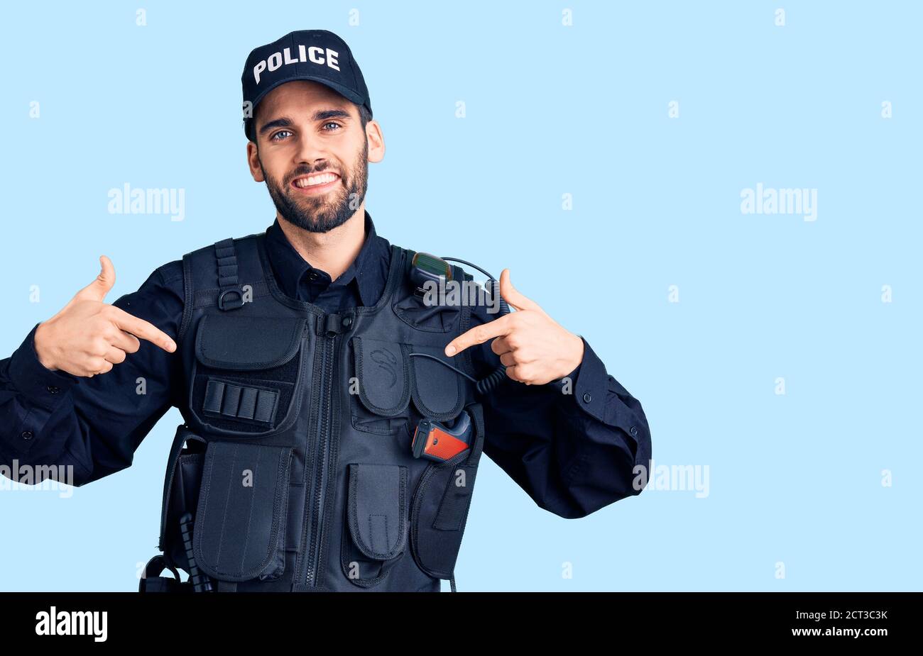 Young handsome man with beard wearing police uniform looking confident ...