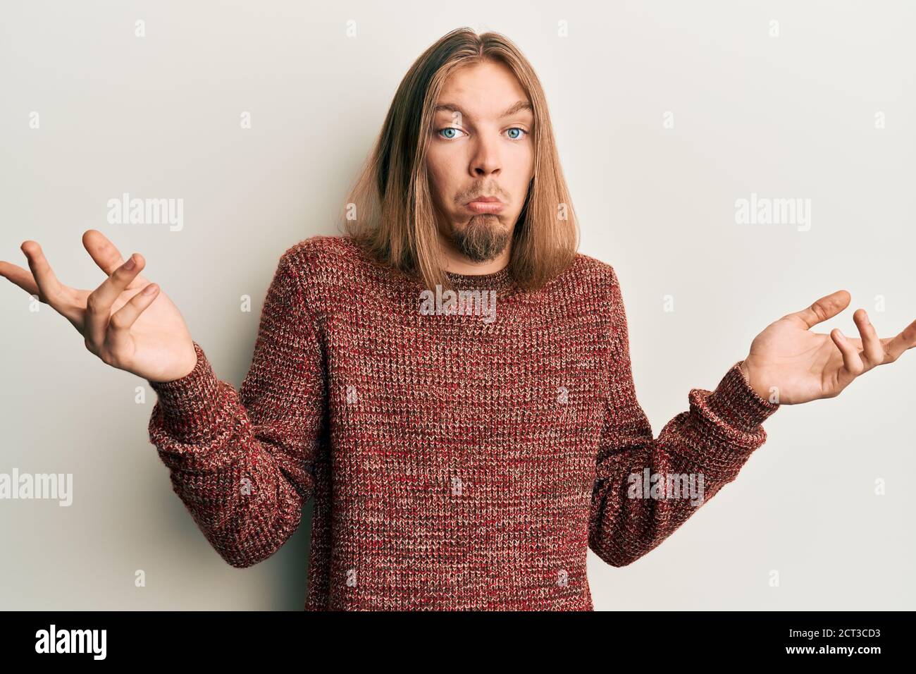 Handsome caucasian man with long hair wearing casual winter sweater ...