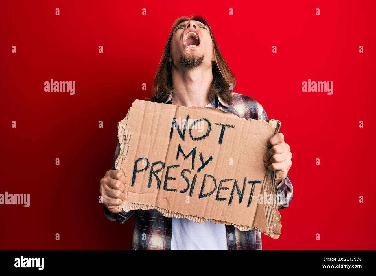 Handsome caucasian man with long hair holding not my president protest ...