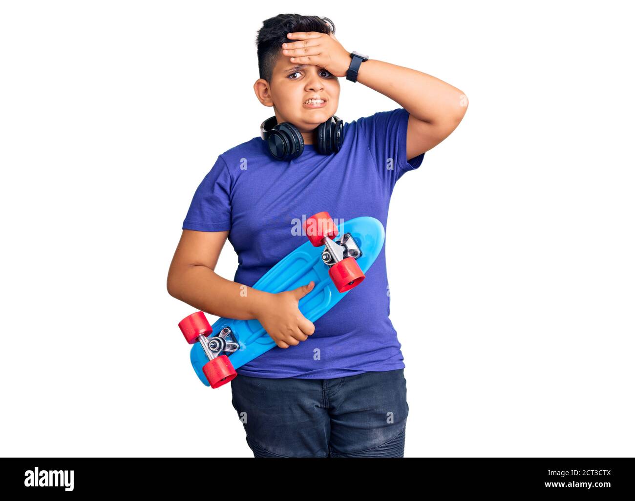 Little boy kid holding skate and wearing headphones stressed and ...