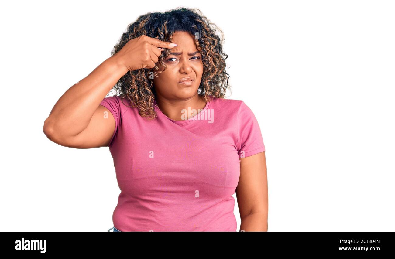 Young african american plus size woman wearing casual clothes pointing ...