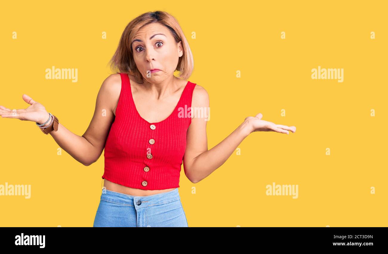 Young blonde woman wearing casual clothes clueless and confused ...