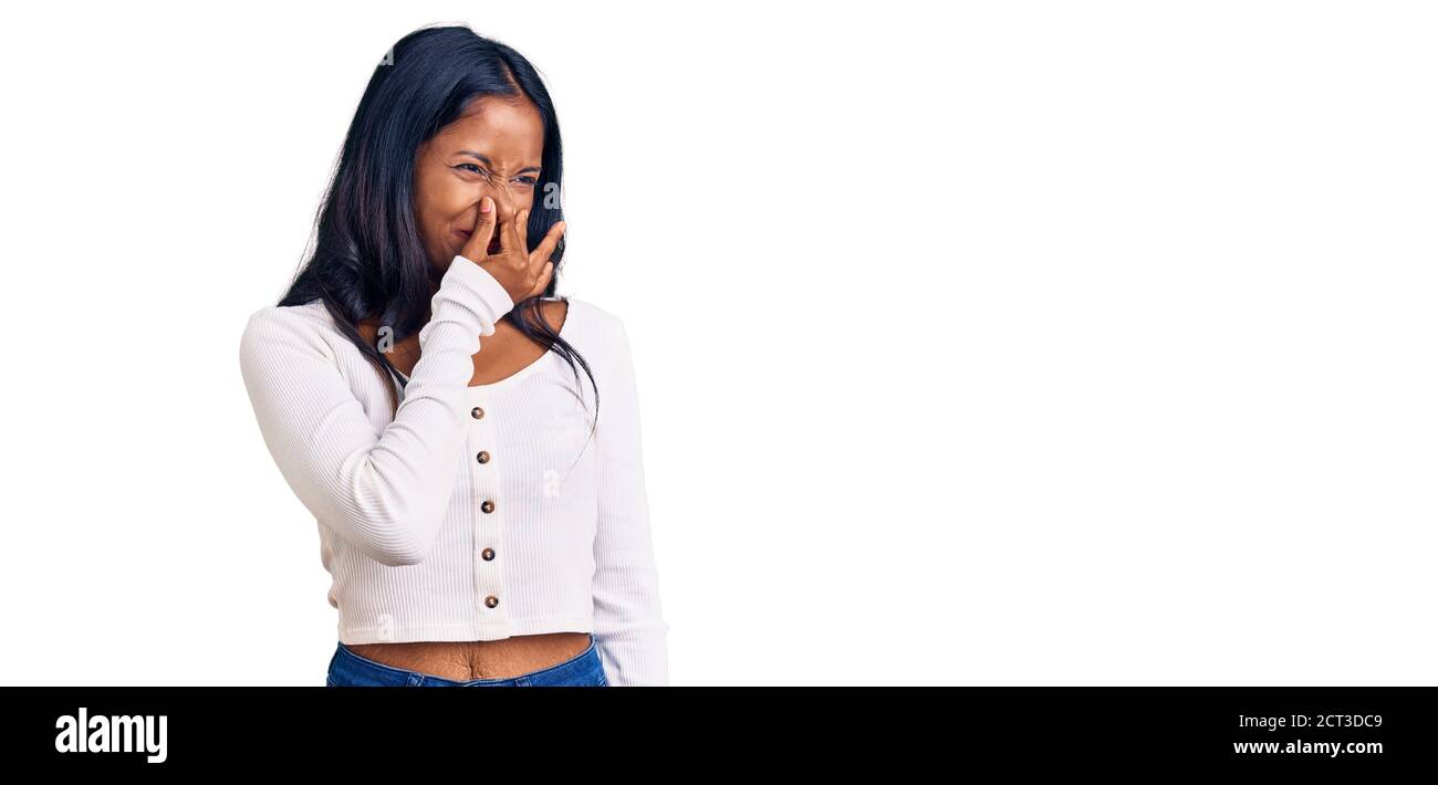 Young Indian Girl Wearing Casual Clothes Smelling Something Stinky And