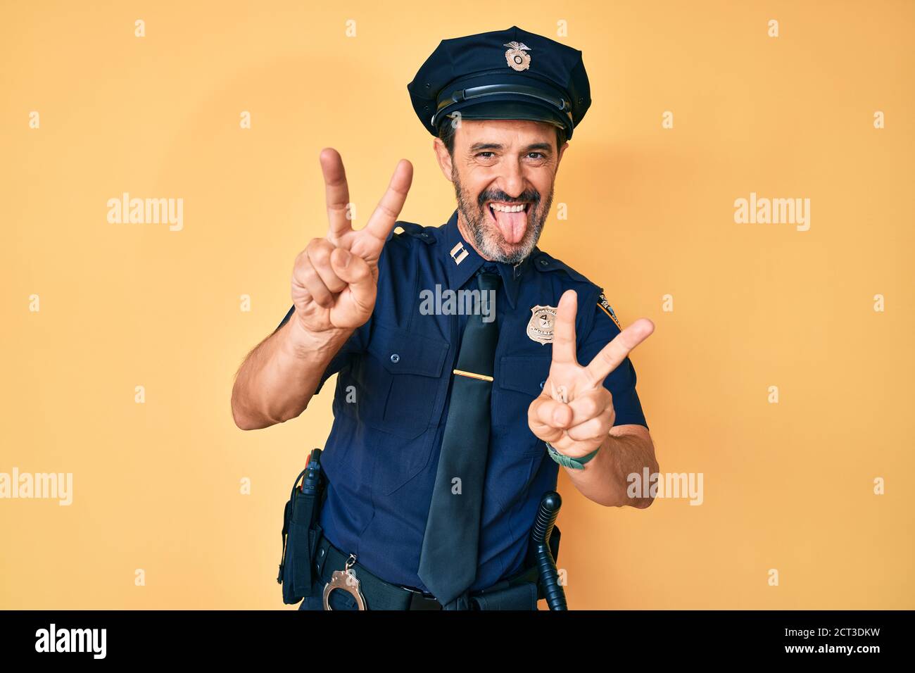 Middle age hispanic man wearing police uniform smiling with tongue out ...