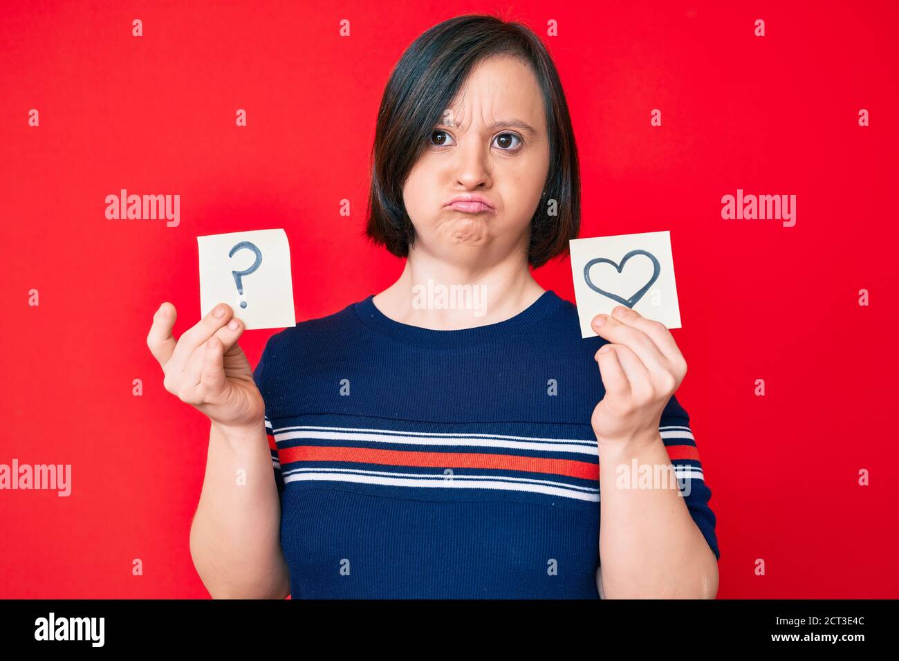 Brunette woman with down syndrome holding heart and question mark ...