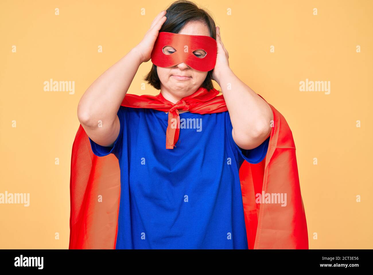 Brunette woman with down syndrome wearing super hero costume suffering ...
