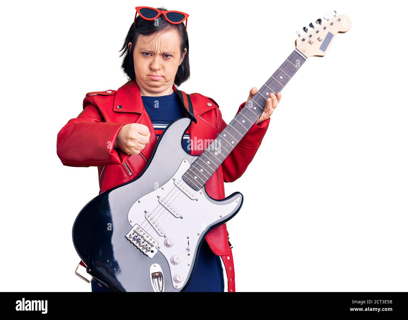 Brunette woman with down syndrome playing electric guitar annoyed and ...