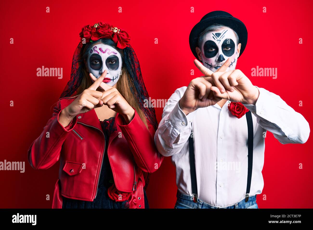 Couple wearing day of the dead costume over red rejection expression ...