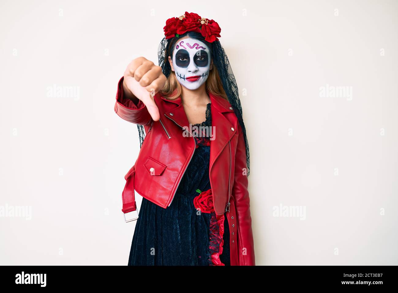 Woman wearing day of the dead costume over white looking unhappy and ...