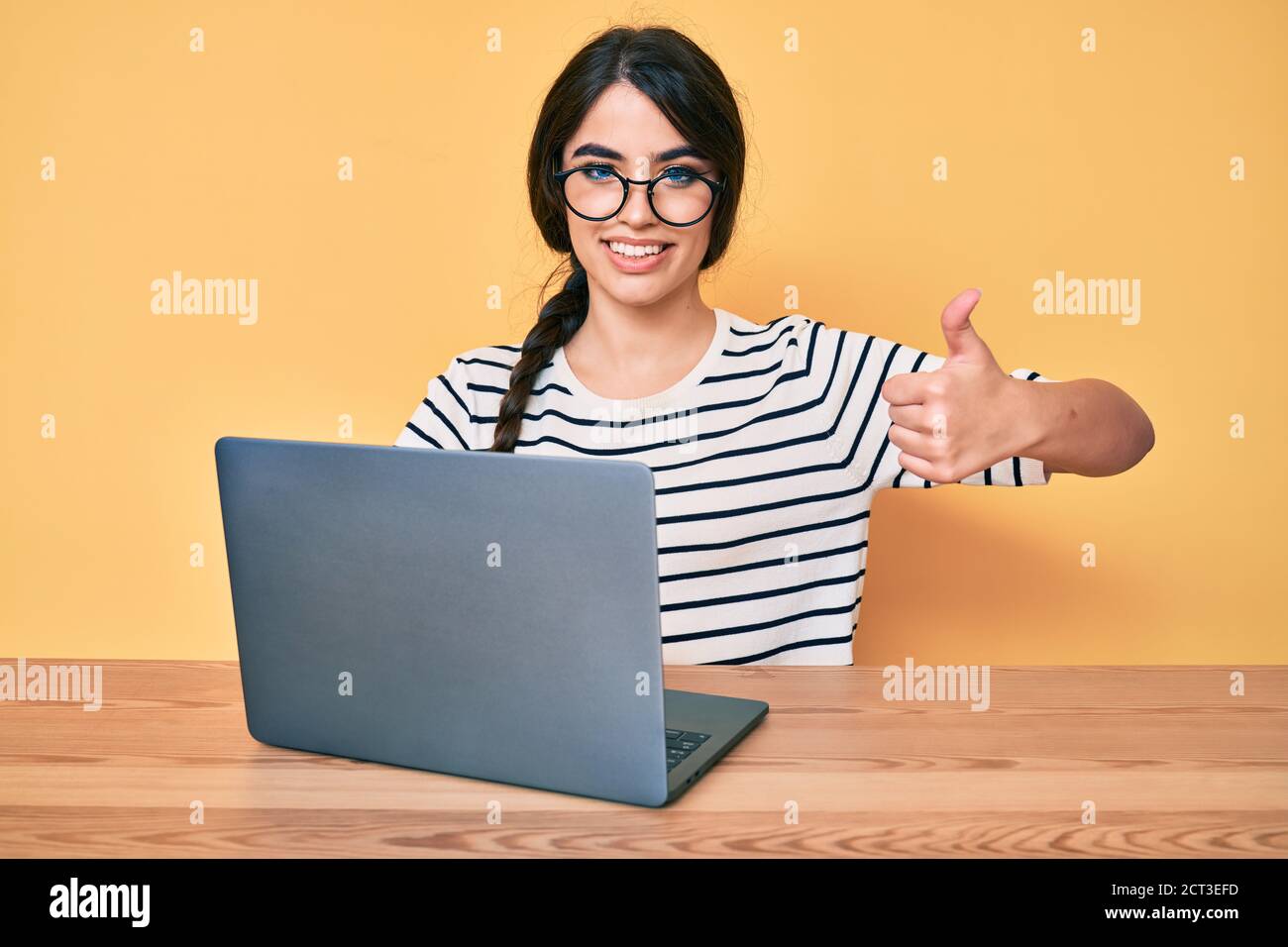 Brunette teenager girl working using computer laptop smiling happy and ...