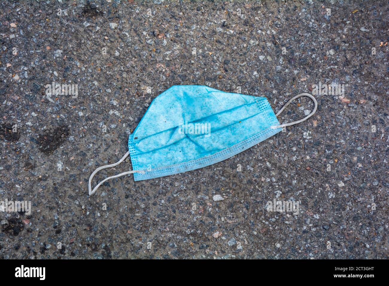 Used blue medical face mask on asphalt. Discarded medical face mask on ...
