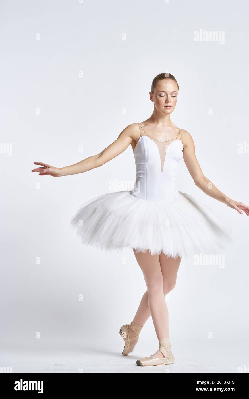 Ballerina in a white tutu dance performed on a light background Stock ...