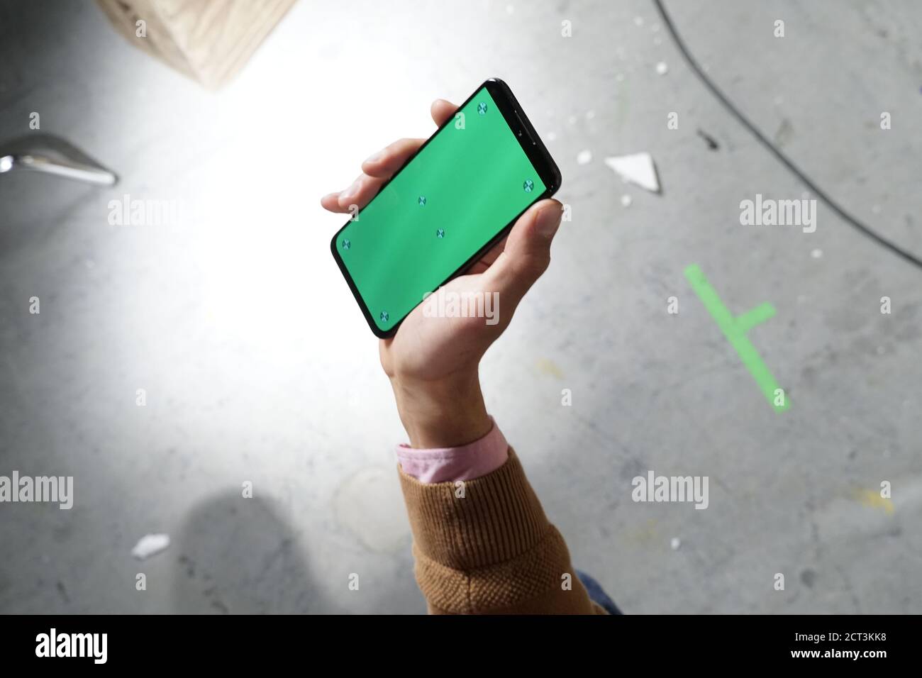 closeup of hand holding mobile phone with greenscreen to be as mocap ...