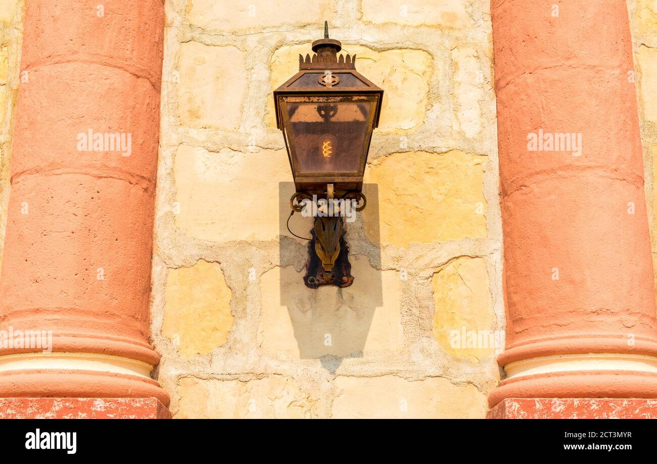 a vintage carriage lamp between two columns at a California mission ...