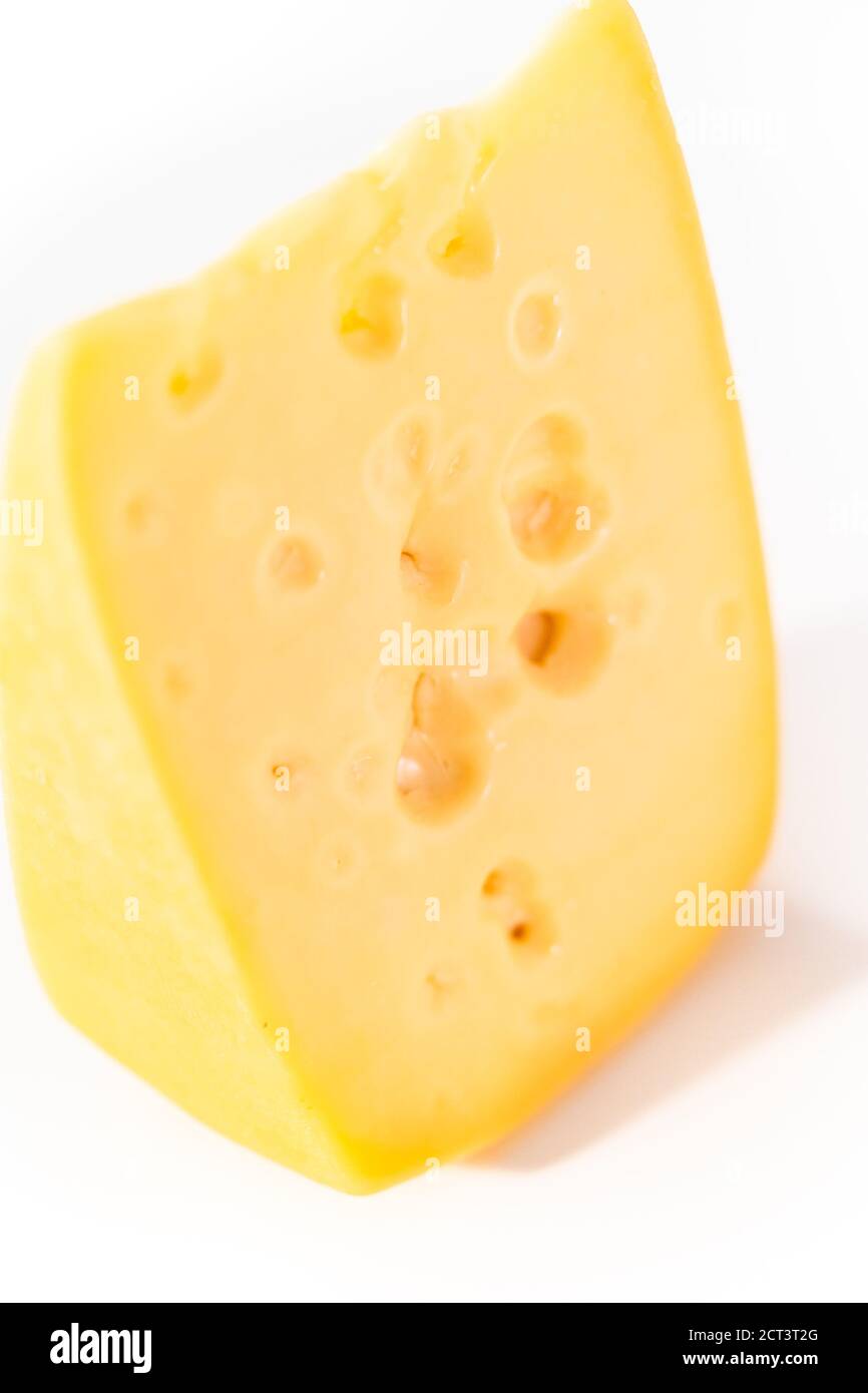 Large slice of semi soft part skim cheese on a white background Stock ...