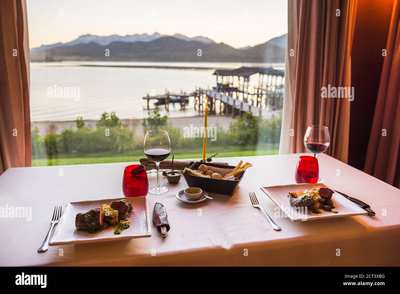 Table set up for dinner at a fine dining restaurant with a glass of red ...
