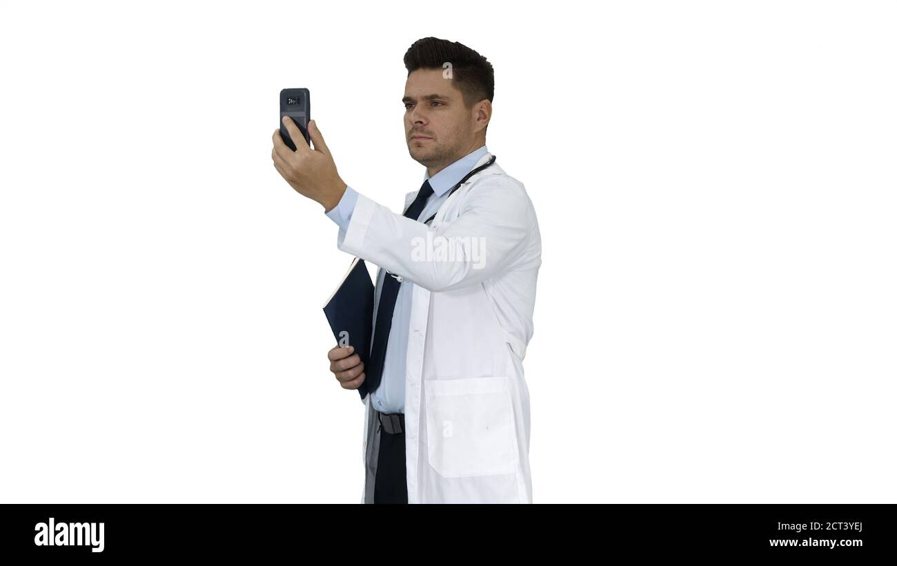 Male doctor making a video call talking to his patient on white ...