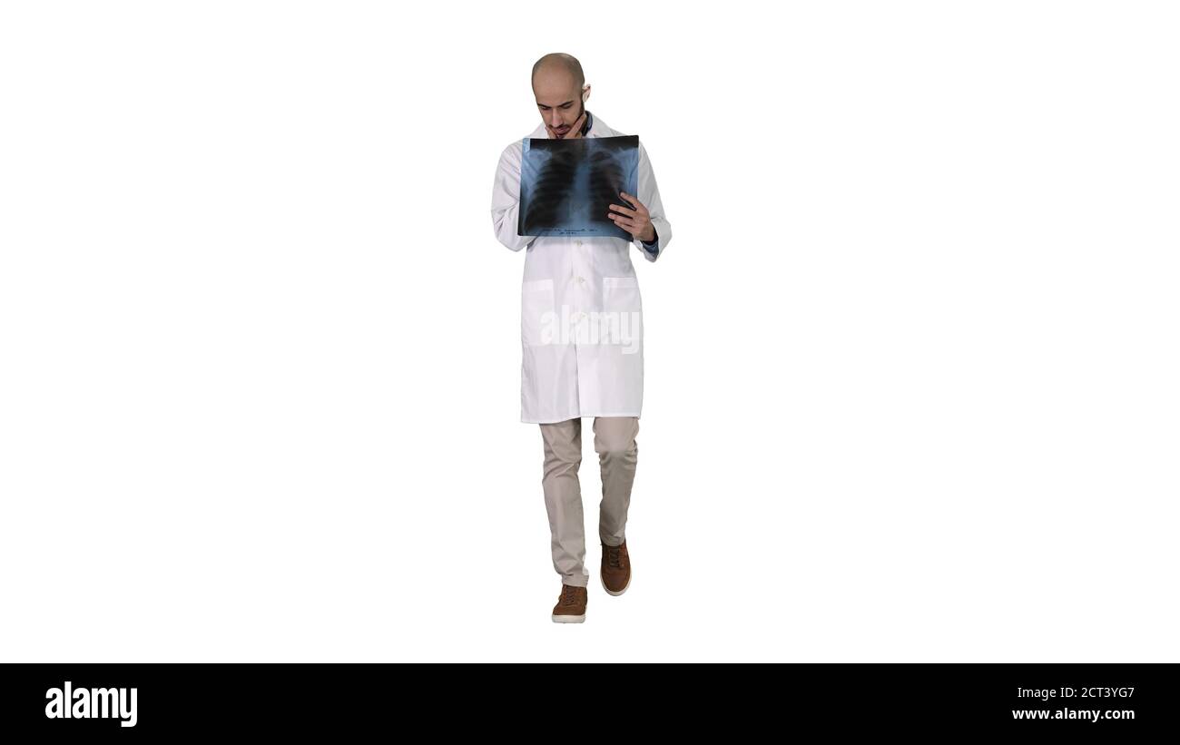 Doctor radiologist looking at x-ray scan walking on white background ...