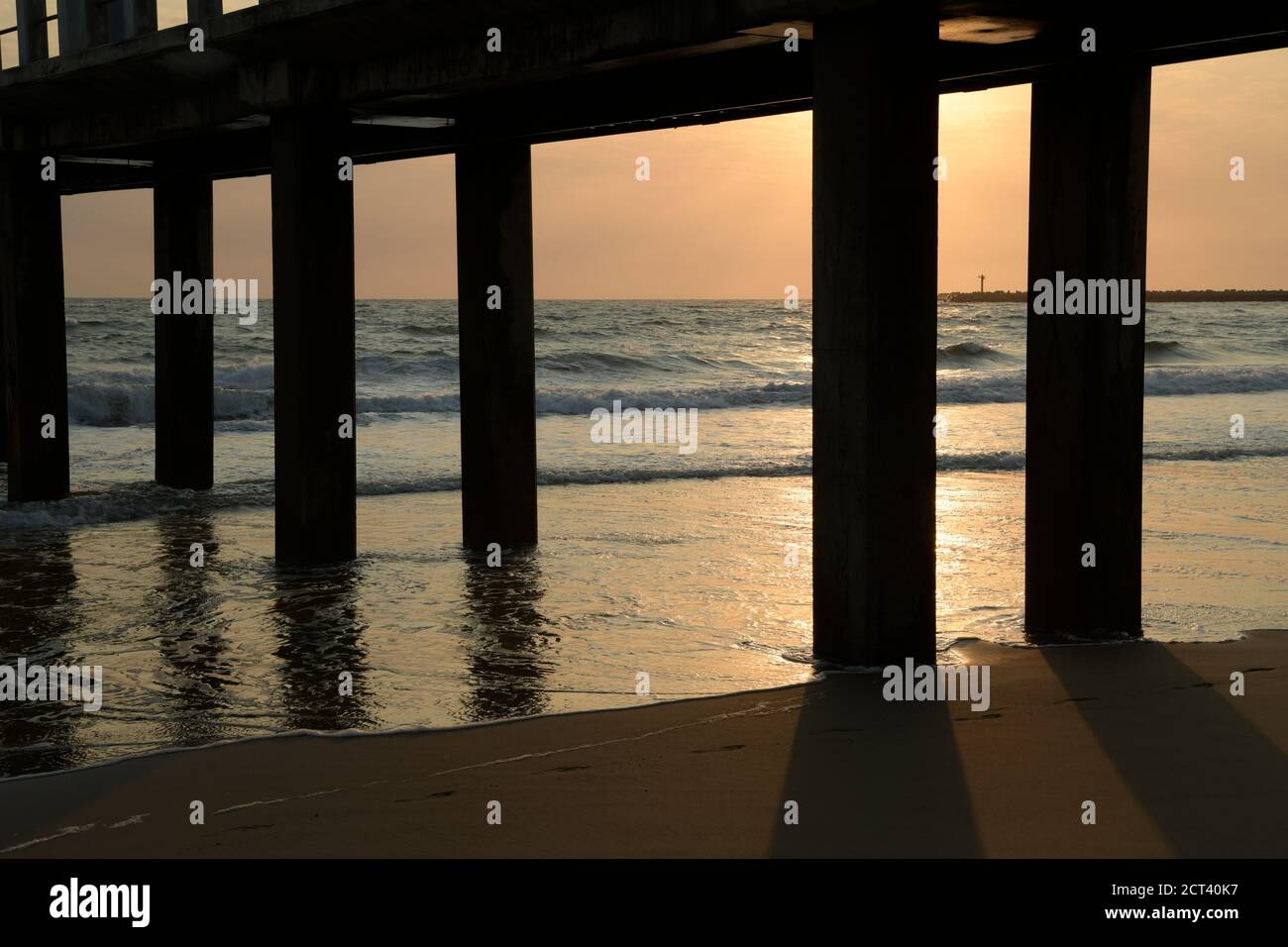 Silhouette of jetty, outline of pillars, sunrise glow, minimal ...