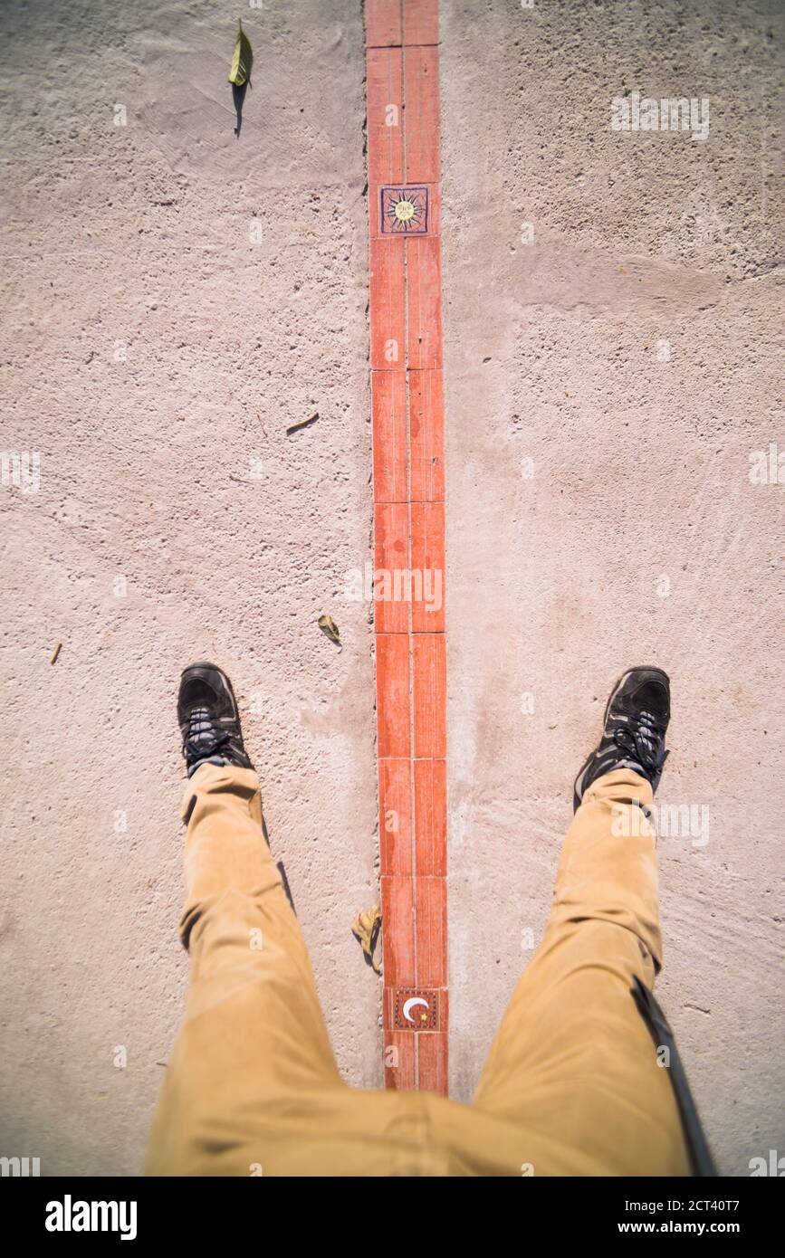 One foot on either side of the Equator at the 'Middle of the World ...