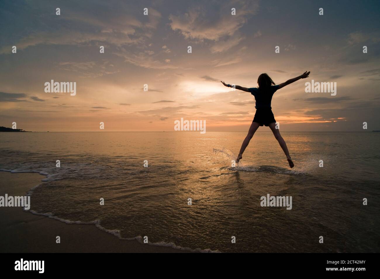 Young woman celebrating on beach jump jumping hi-res stock photography ...