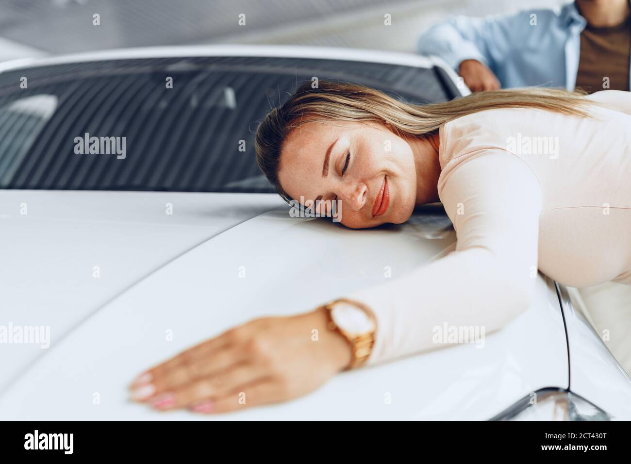 Young couple man and woman hugging their new car in a car shop Stock ...