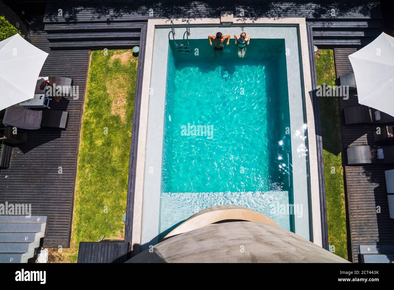 Couple at a swimming pool on vacation at luxury hotel accommodation ...