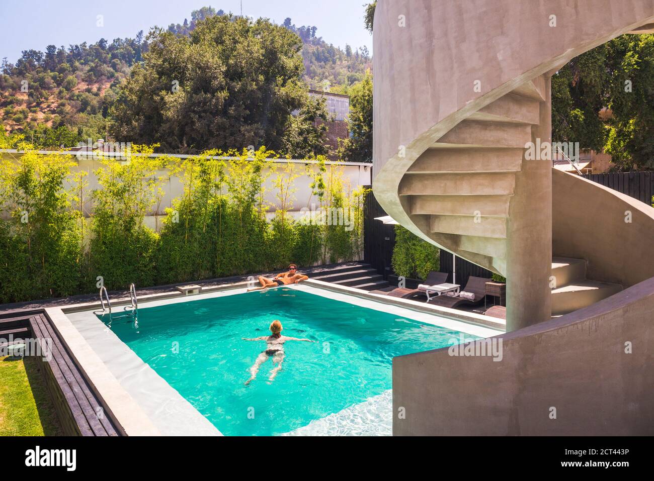 Couple at a swimming pool on vacation at luxury hotel accommodation ...