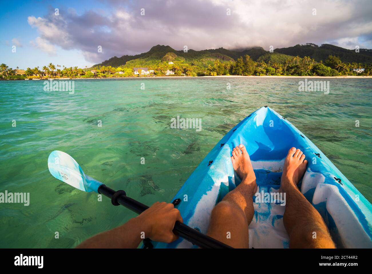 Kayaking at sunrise by a tropical island at Muri Lagoon, Rarotonga ...