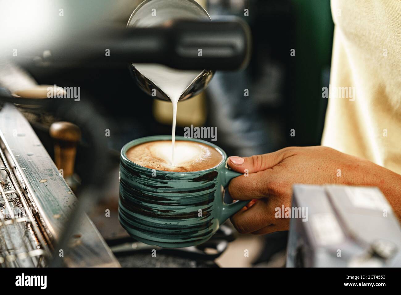 Woman coffee shop worker preparing coffee on professional coffee ...