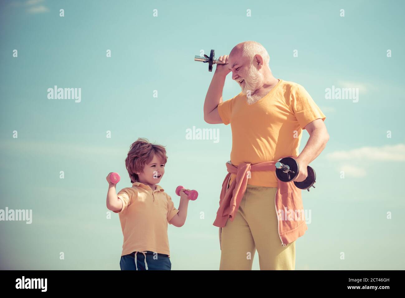 Healthy upbringing. Old mature man and little boy exercising with ...
