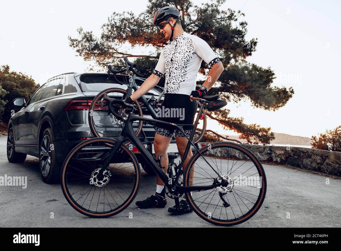 Male cyclist loading his bicycle on a rack of his crossover car Stock ...