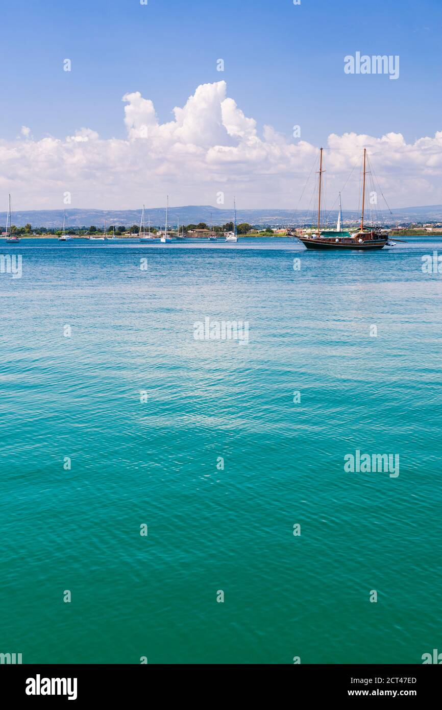 Sailing boat on the turquoise Mediterranean Sea at Ortigia harbour ...