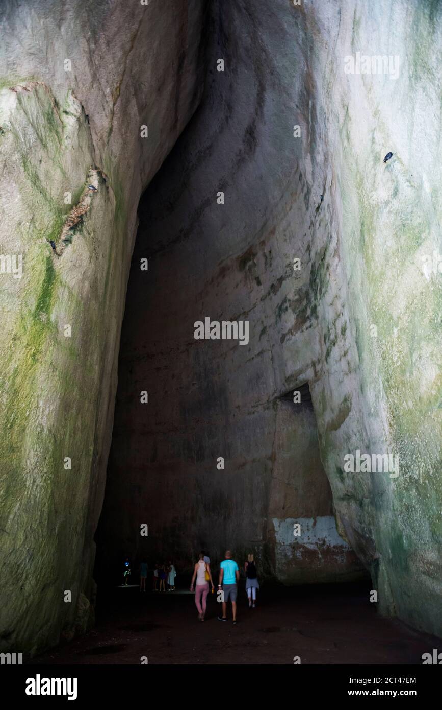 Tourists in a cave at the quarry Garden at the Archeological Park of ...