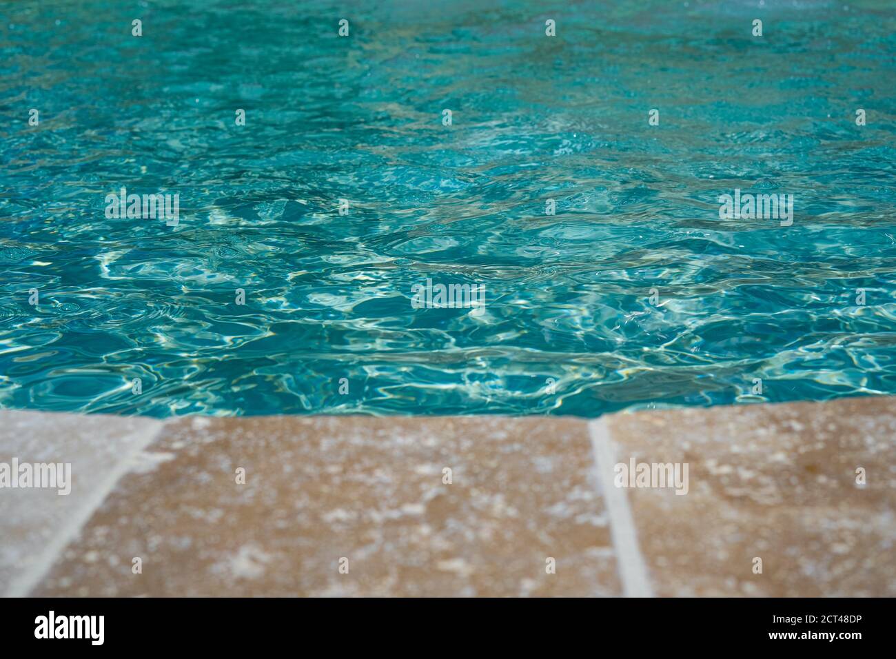 Open swimming pool edge, water and beige marble texture. Vacation ...