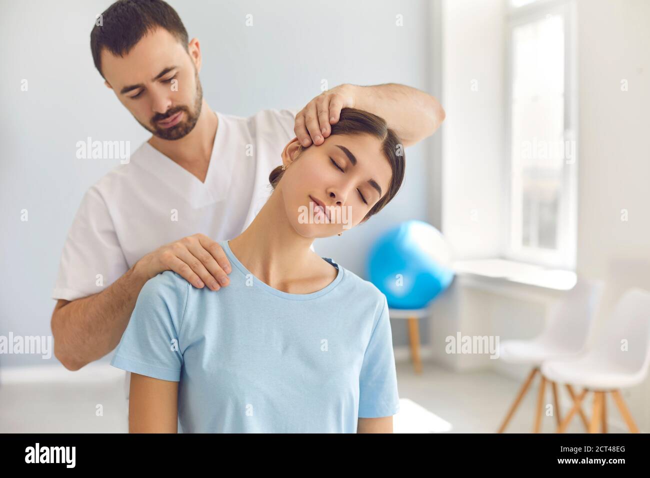 Licensed chiropractor doing neck adjustment to female patient in modern ...
