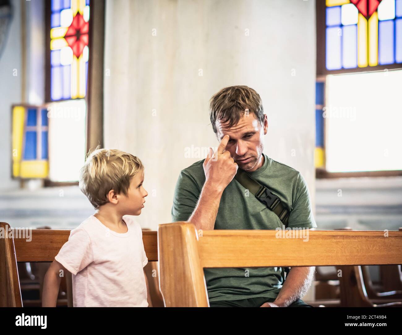 Christian dad tells his son Bible stories about Jesus sitting in kirk ...