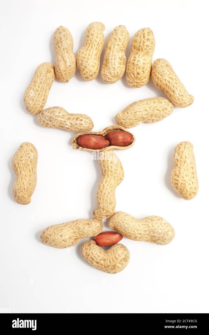 Face made of whole peanut shells on white background Stock Photo - Alamy