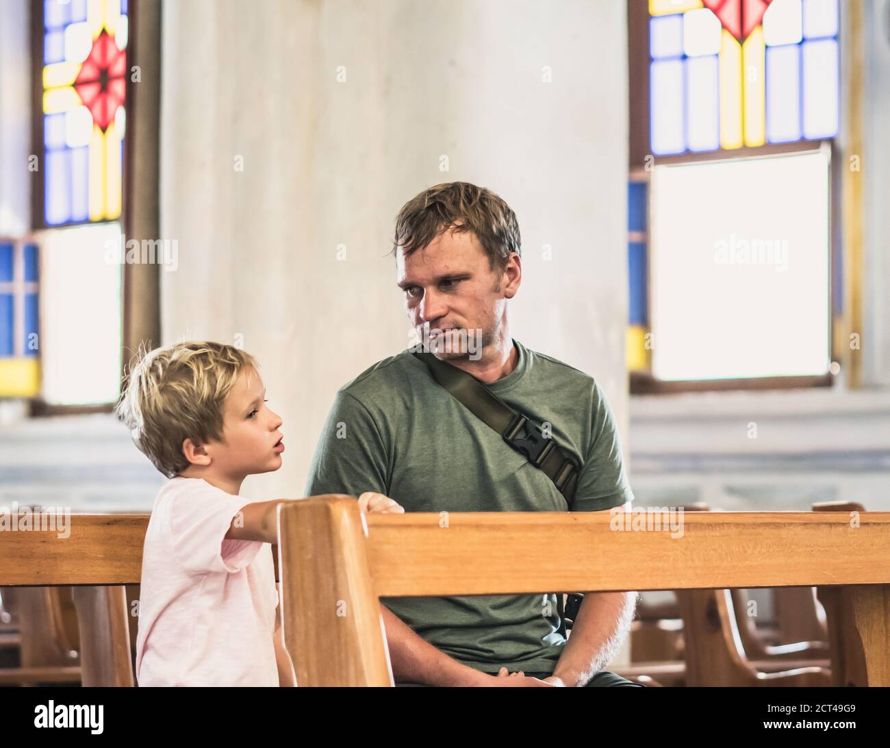 Christian dad tells his son Bible stories about Jesus sitting in kirk ...