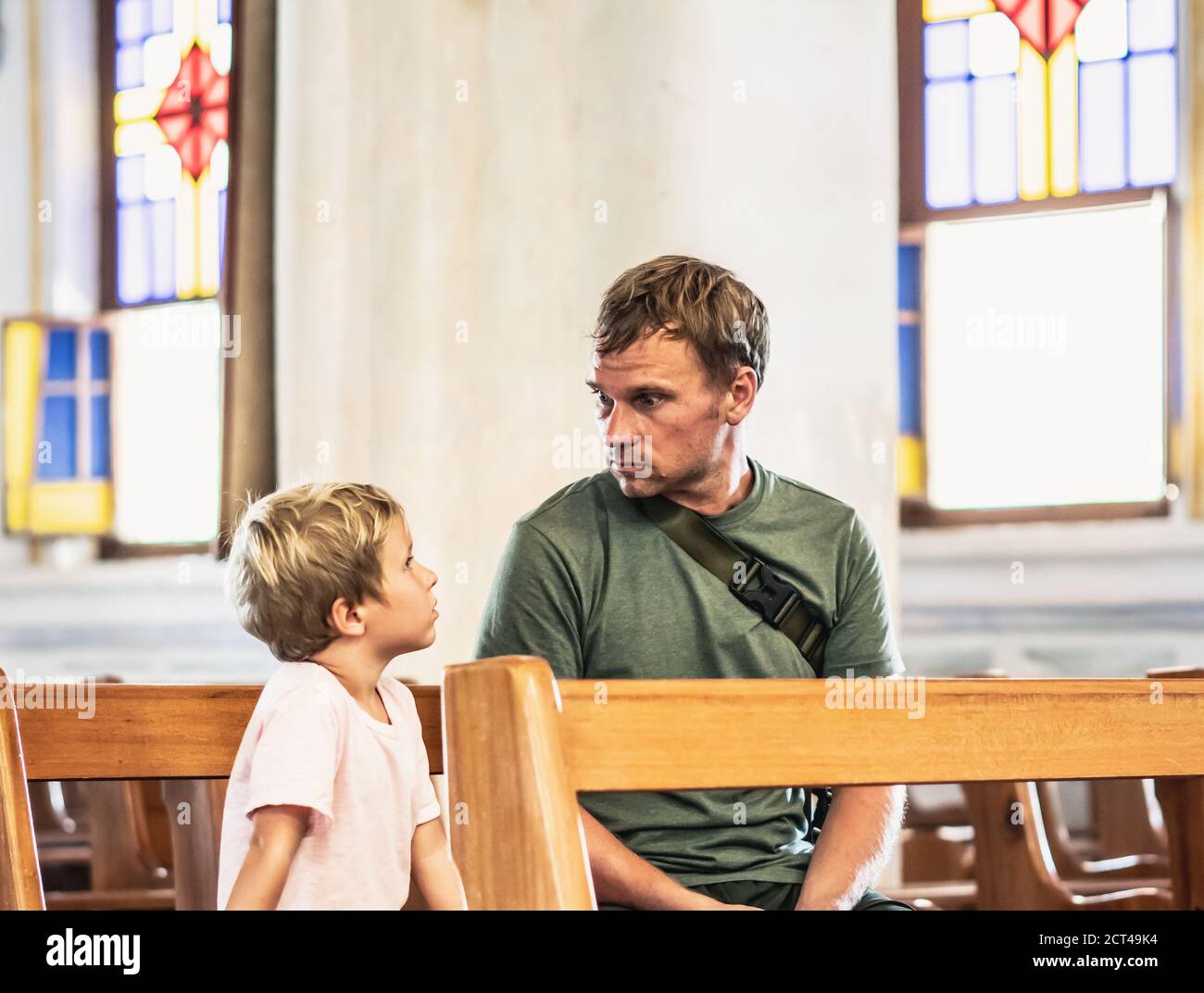 Christian dad tells his son Bible stories about Jesus sitting in kirk ...