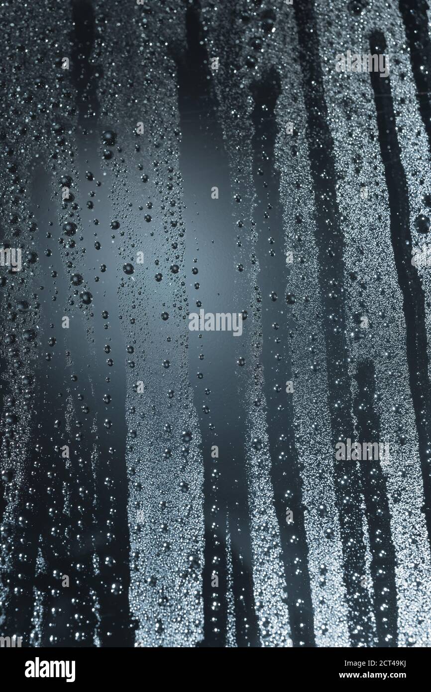 Water drops and water mist hang picturesquely on a glass shelf with ...