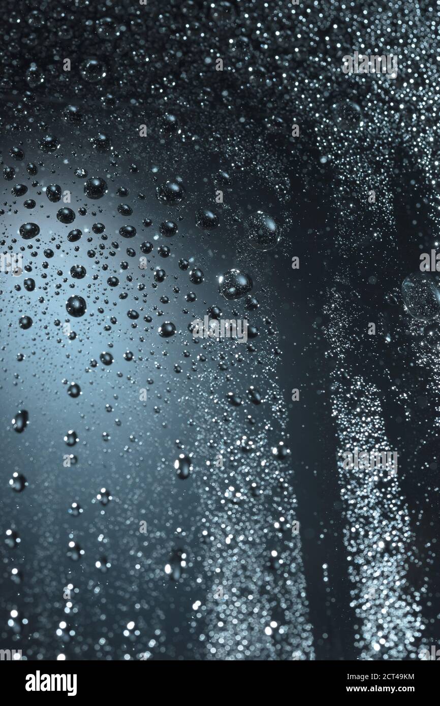 Water drops and water mist hang picturesquely on a glass shelf with ...