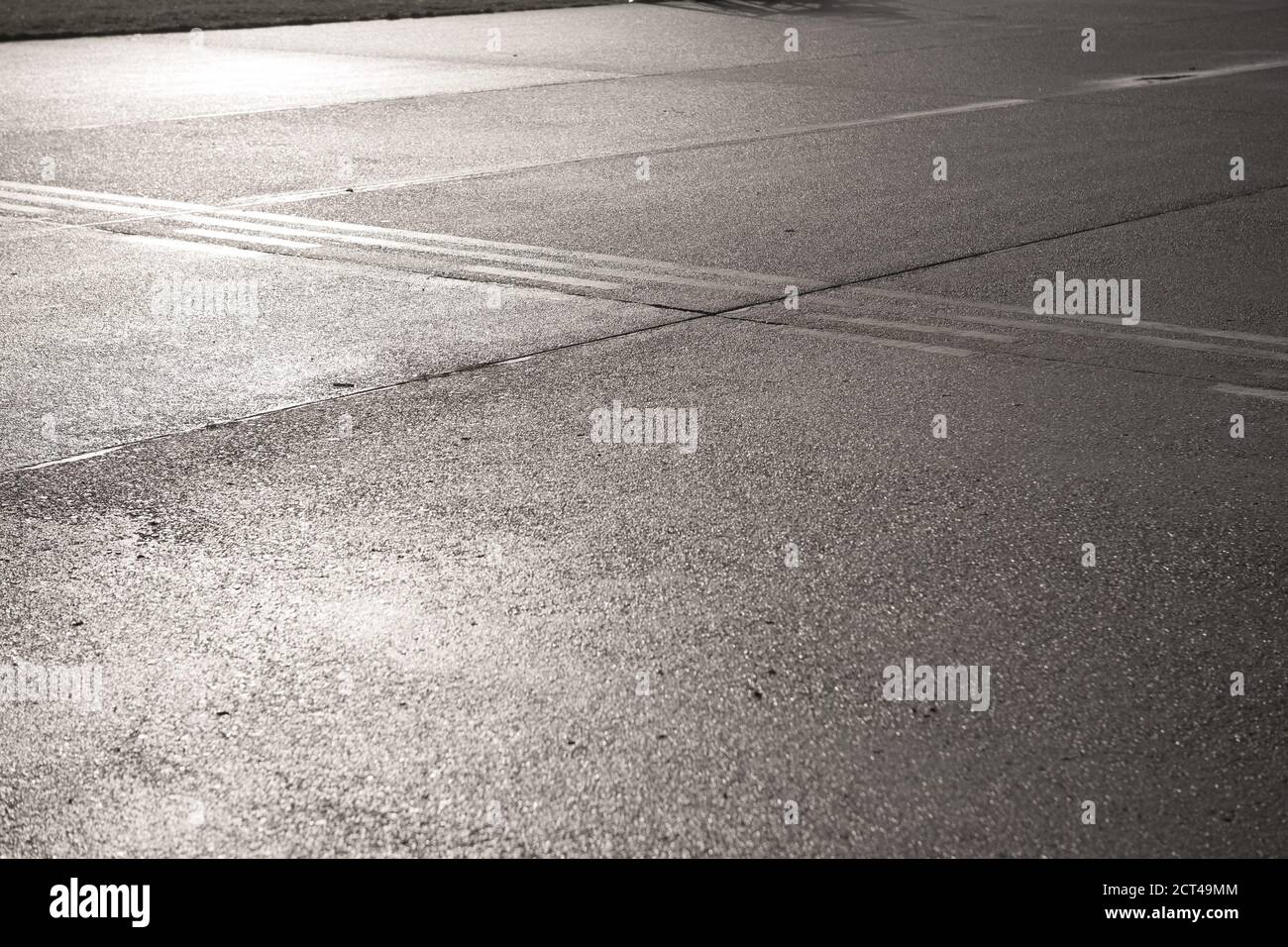 The shiny damp surface of a concrete square appears in large squares in ...
