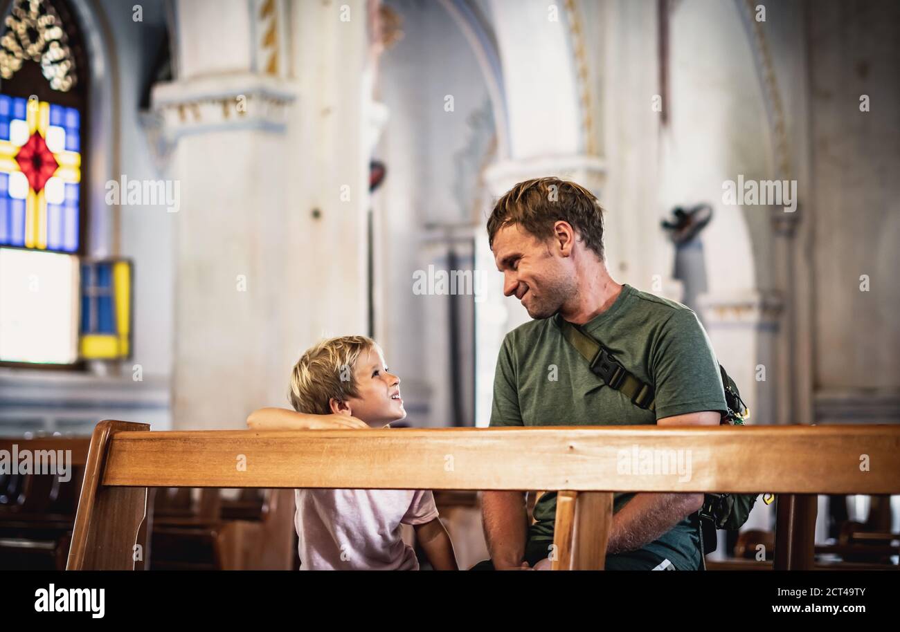 Christian dad tells his son Bible stories about Jesus sitting in kirk ...