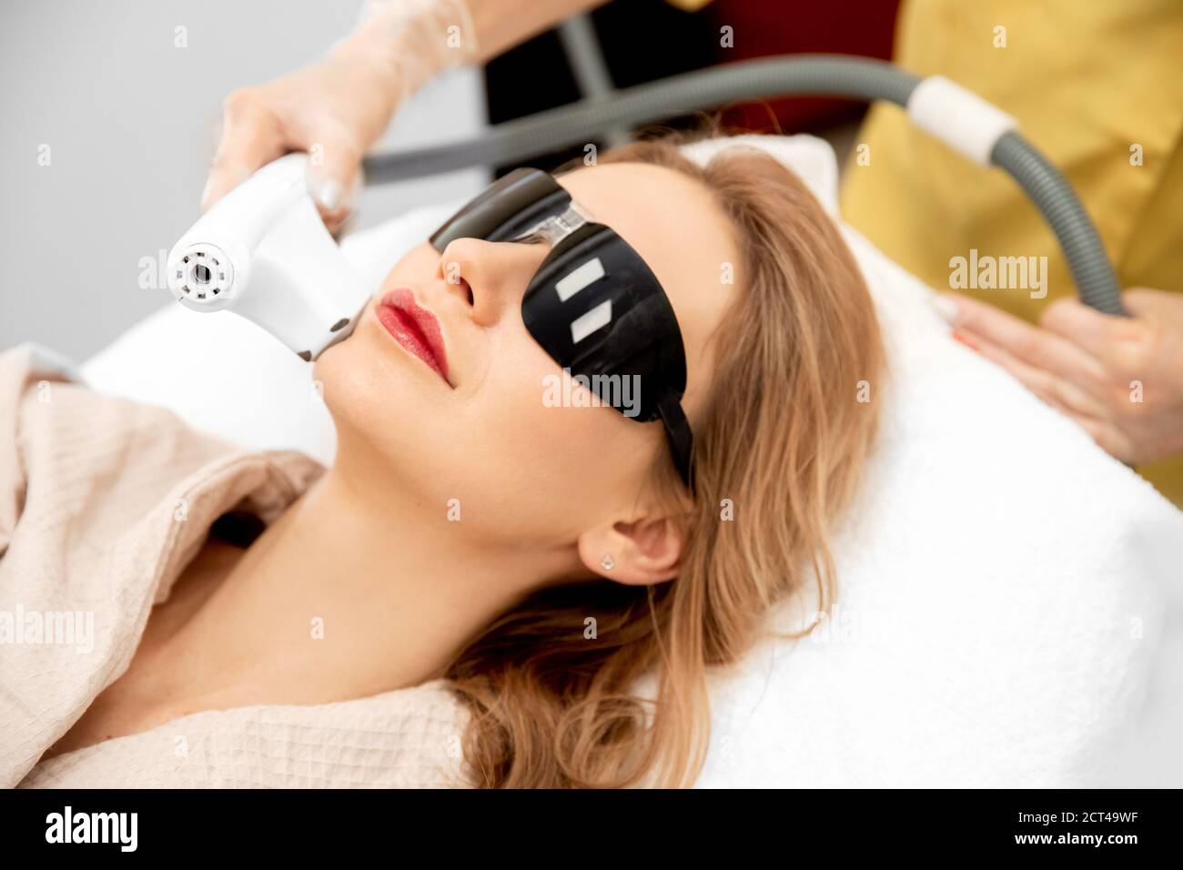 Beautiful woman face receiving laser hair removal procedure beauty ...