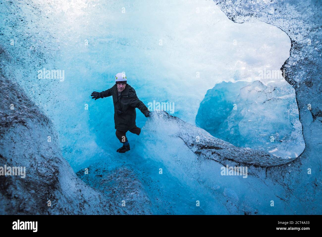 Tourist exploring an ice cave on adventure vacation at ...
